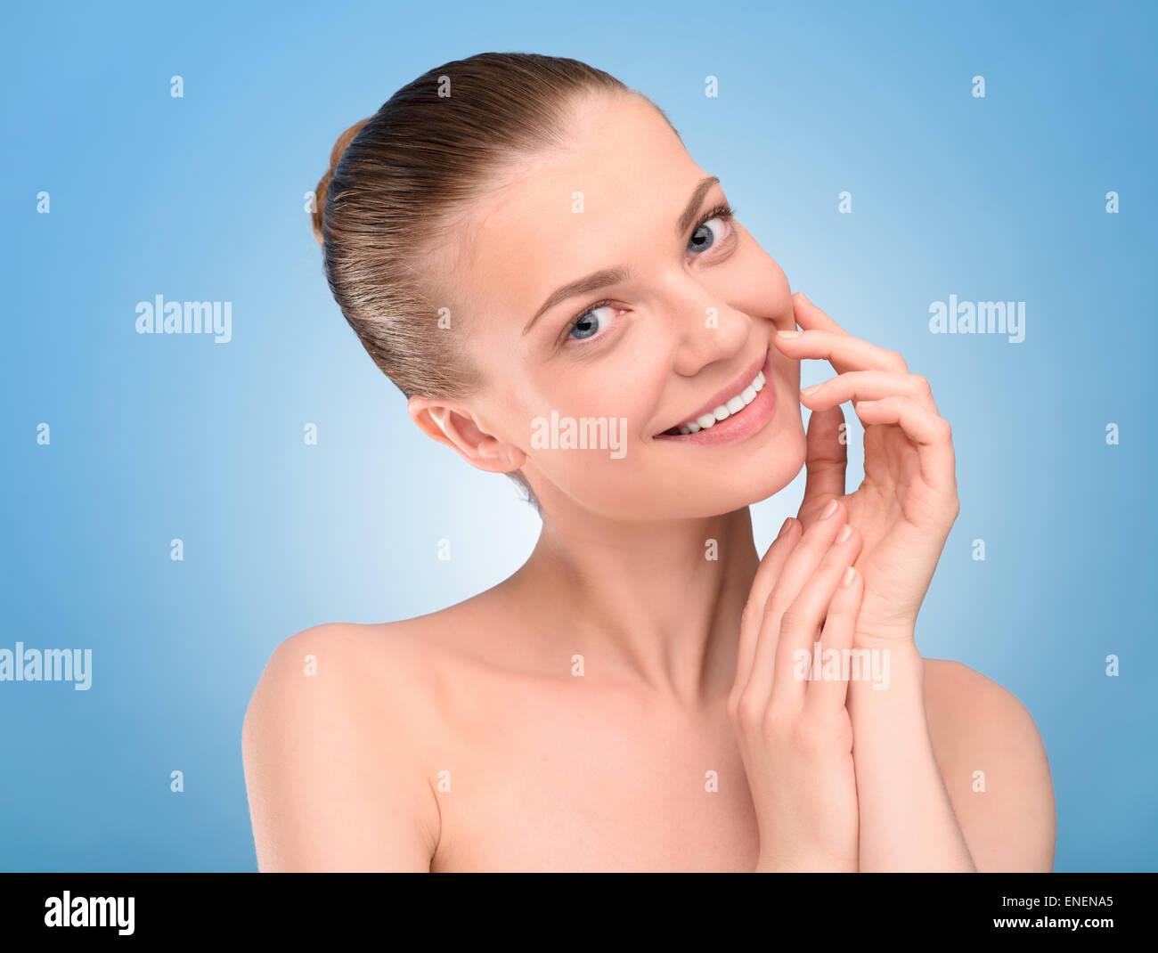 Beautiful woman face looking at camera over blue background. High ...