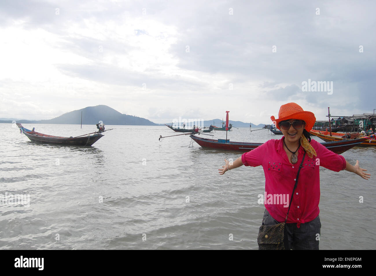 Thai woman playing on the beach at Fishing Village Koh Phithak Island while storm raining in ...