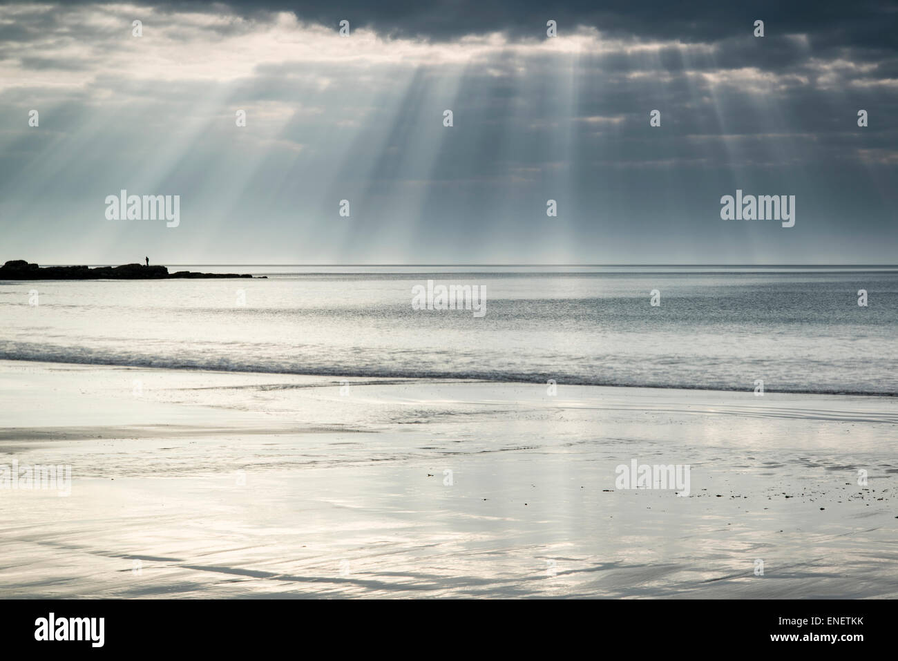 Stunning sun beams bursting from sky over empty yellow sand beach ...