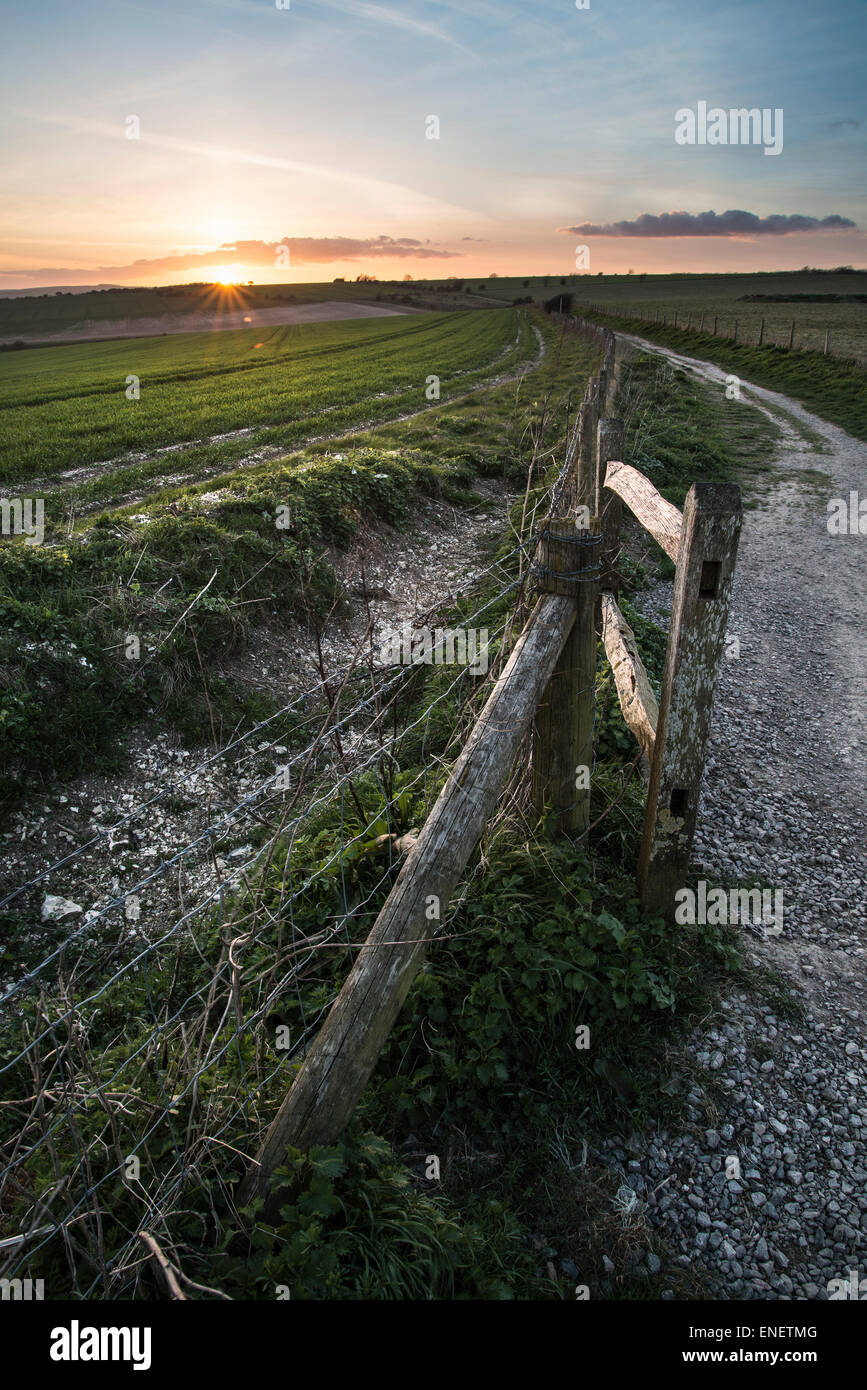 Beautiful Spring landscape of gate leading into fields with setting sun ...