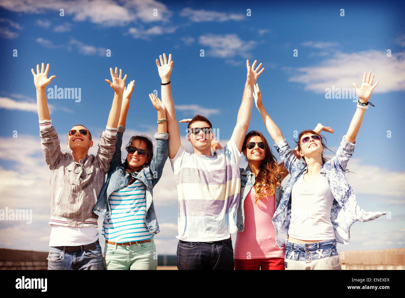 group of smiling teenagers holding hands up Stock Photo - Alamy
