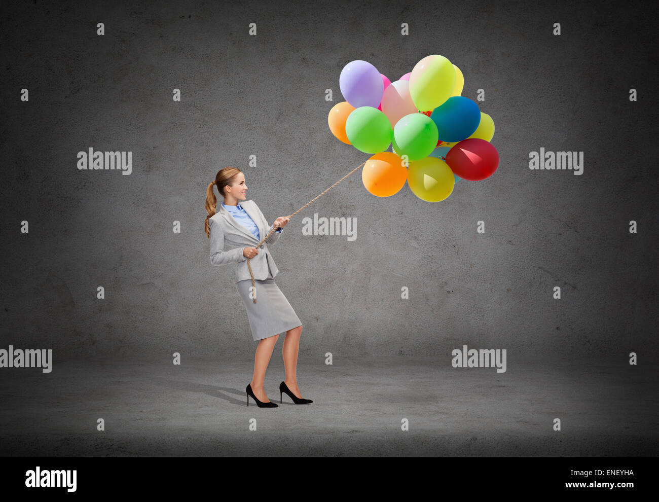 smiling businesswoman pulling rope with balloons Stock Photo - Alamy