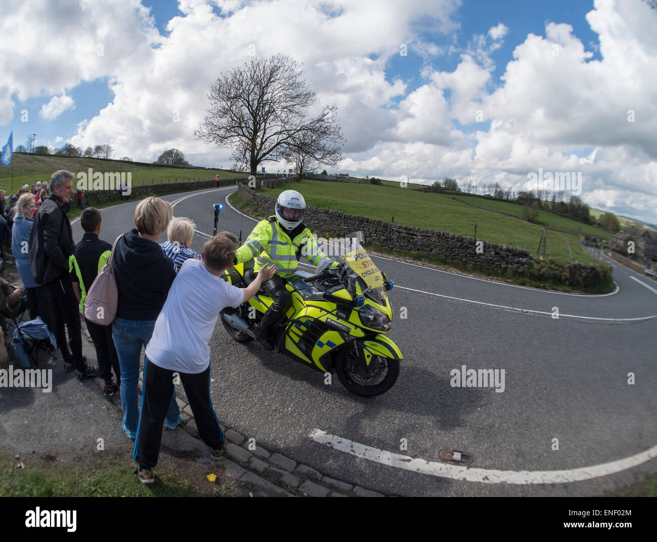 Police motorcyclist giving high 5's to spectators waiting for 2015 Tour ...