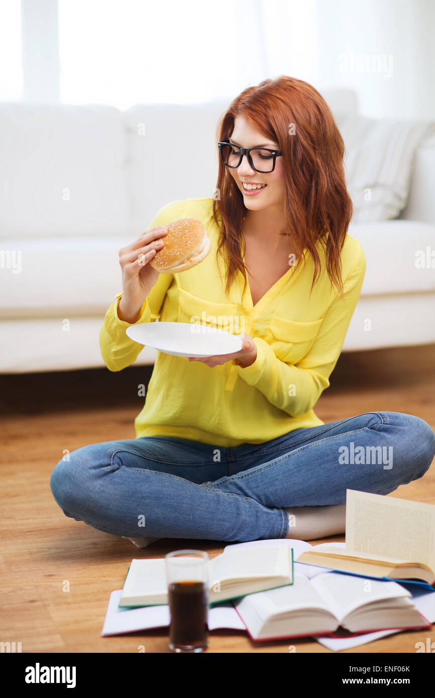 student eating hamburger and doing homework Stock Photo - Alamy