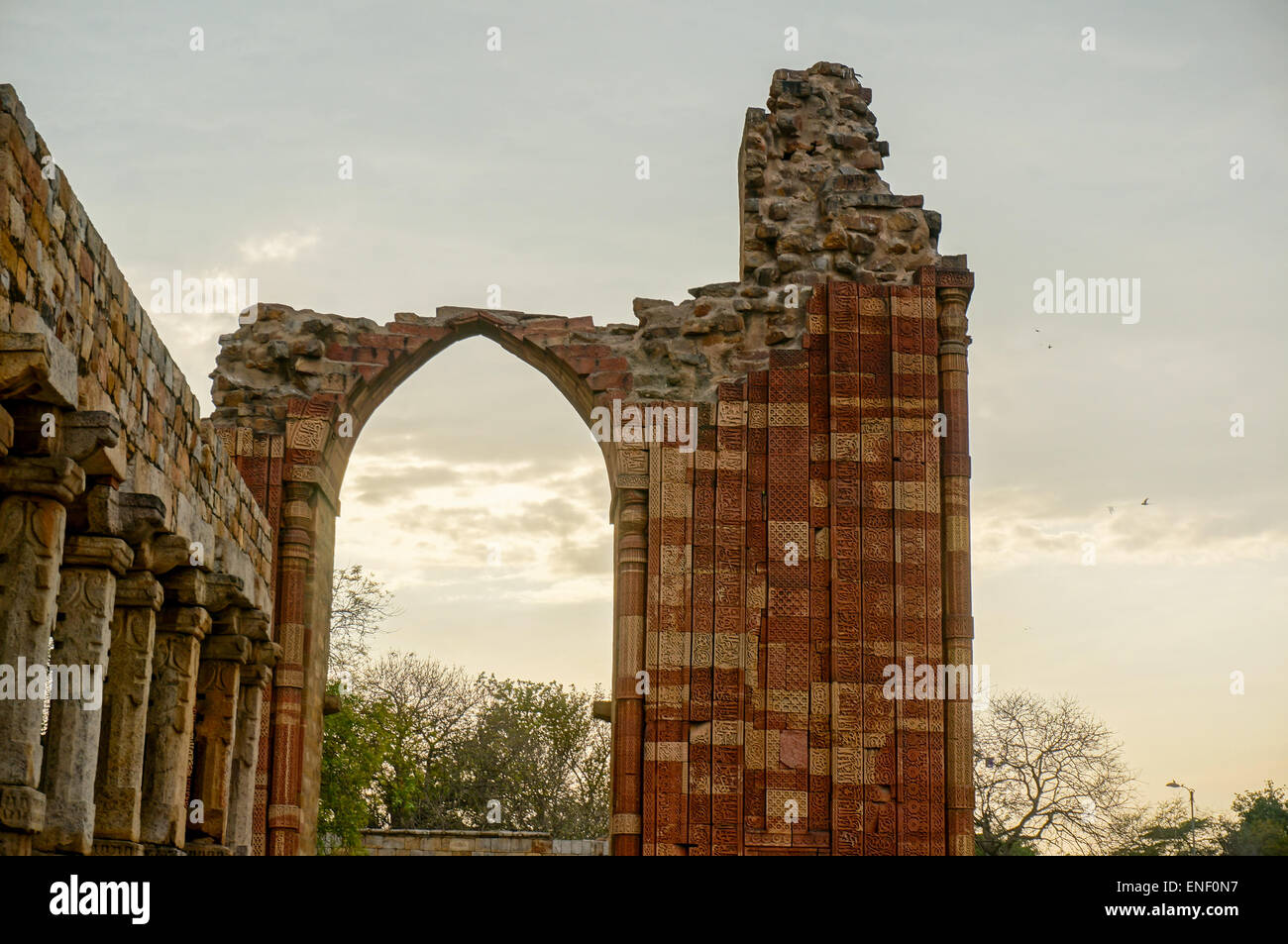 Broen arch at the qutub minar framing a clouded sky. Highlights the ...
