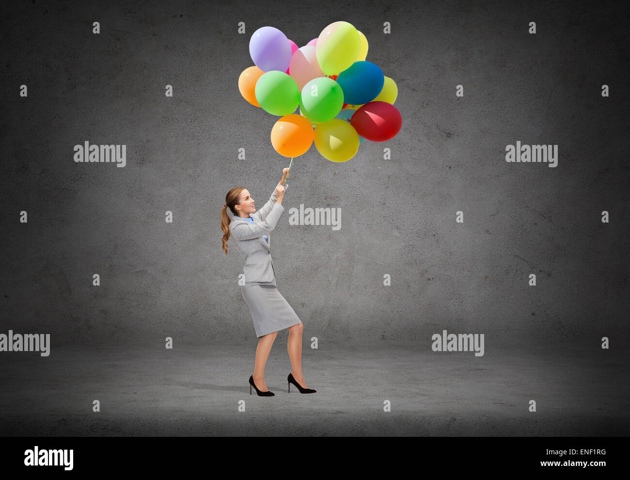 businesswoman pulling down bunch of balloons Stock Photo - Alamy