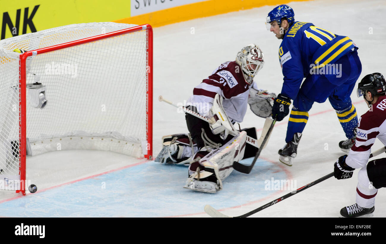 Joakim Lindstrom (SWE), in blue, scores against goalkeeper Edgars Masalskis (LAT) during the Ice ...