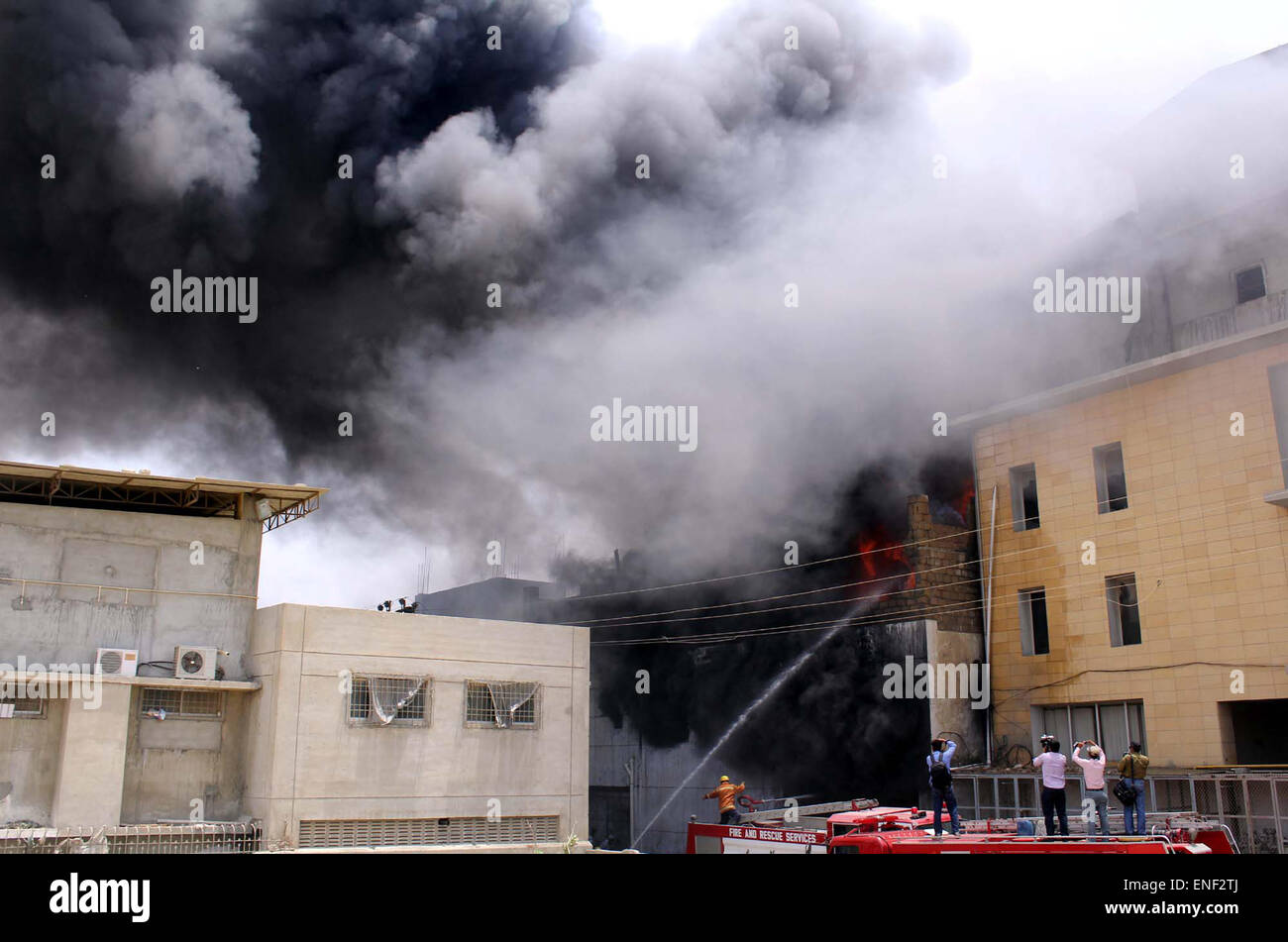Fire fighters extinguishing from burning garments factory building ...