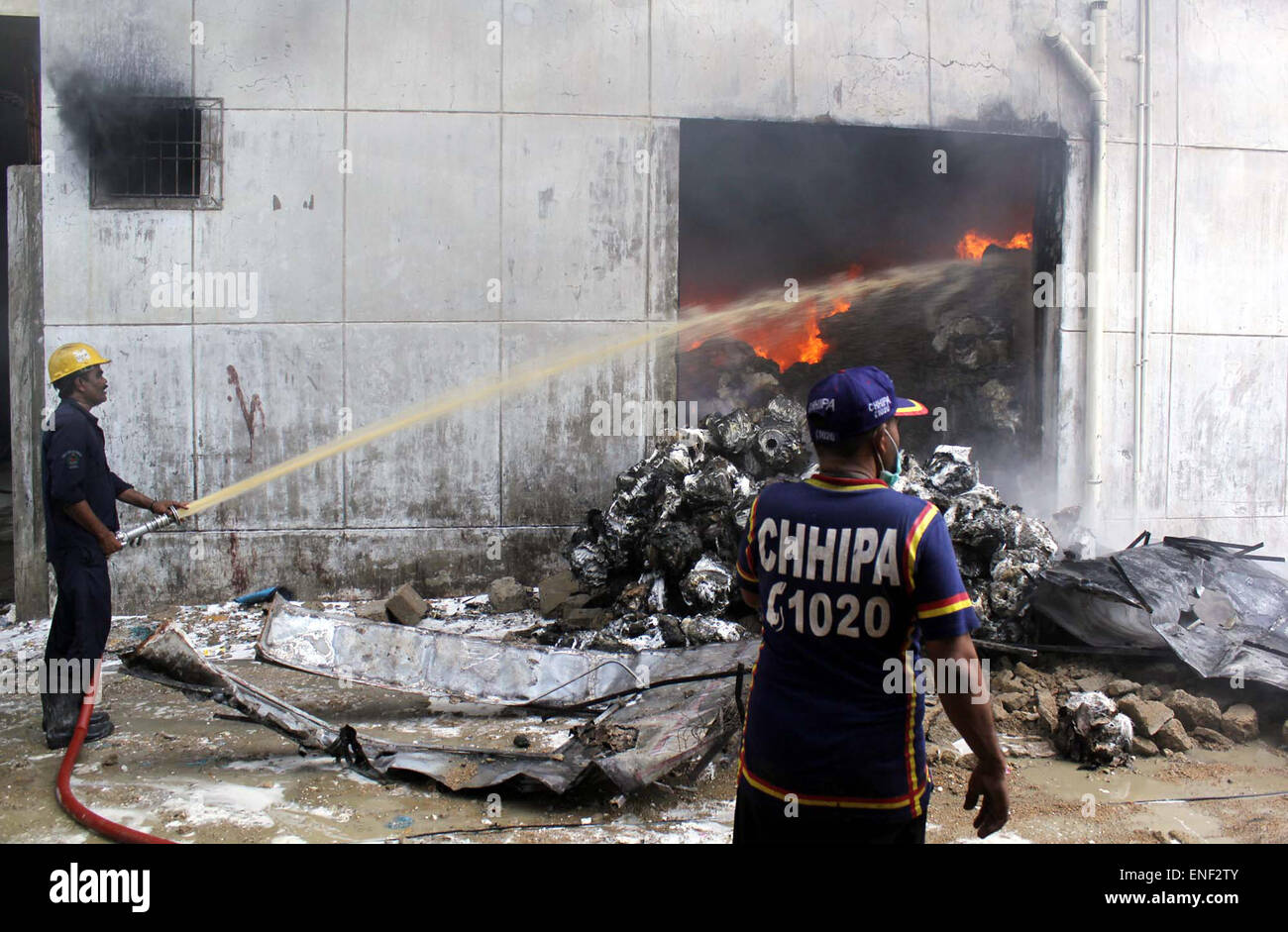 Fire fighters extinguishing from burning garments factory building ...