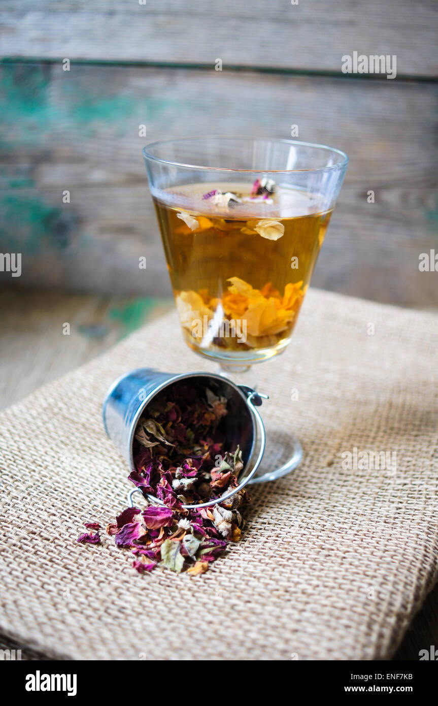Glass cup with fresh green tea and dry roses Stock Photo - Alamy