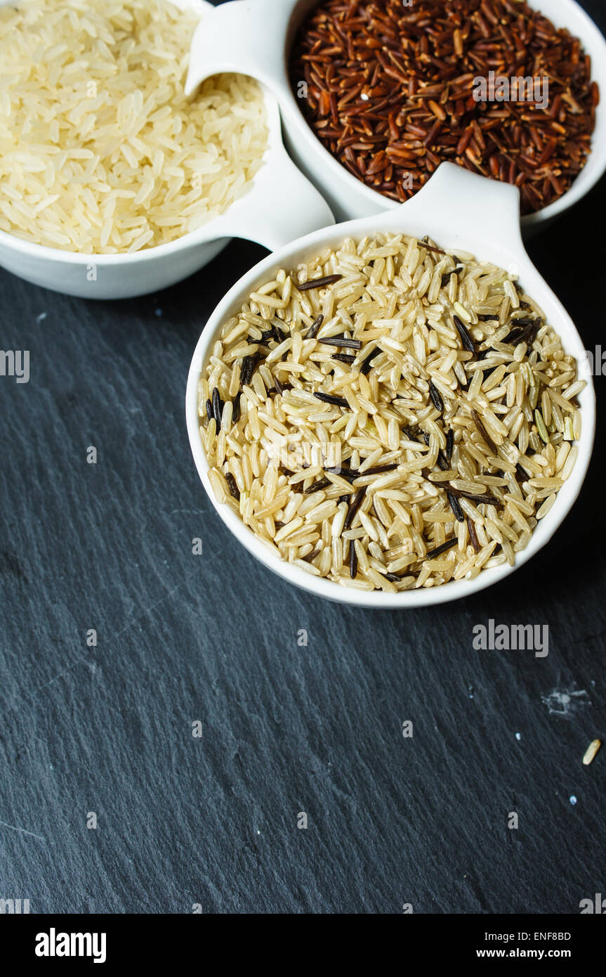 Different kinds of rice in the pots on the rustic table Stock Photo - Alamy
