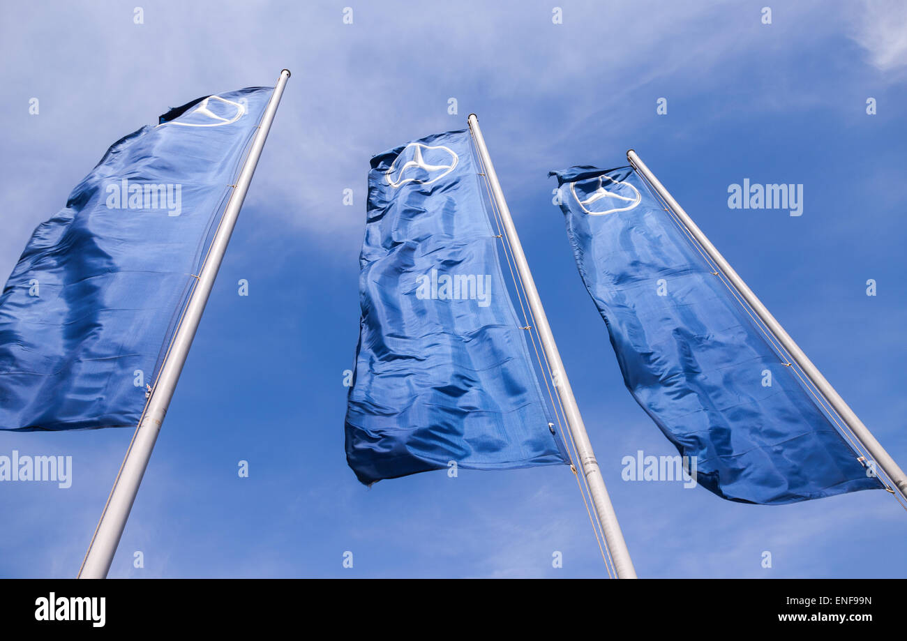 The flags of Mercedes-Benz over blue sky. Mercedes-Benz is a German ...