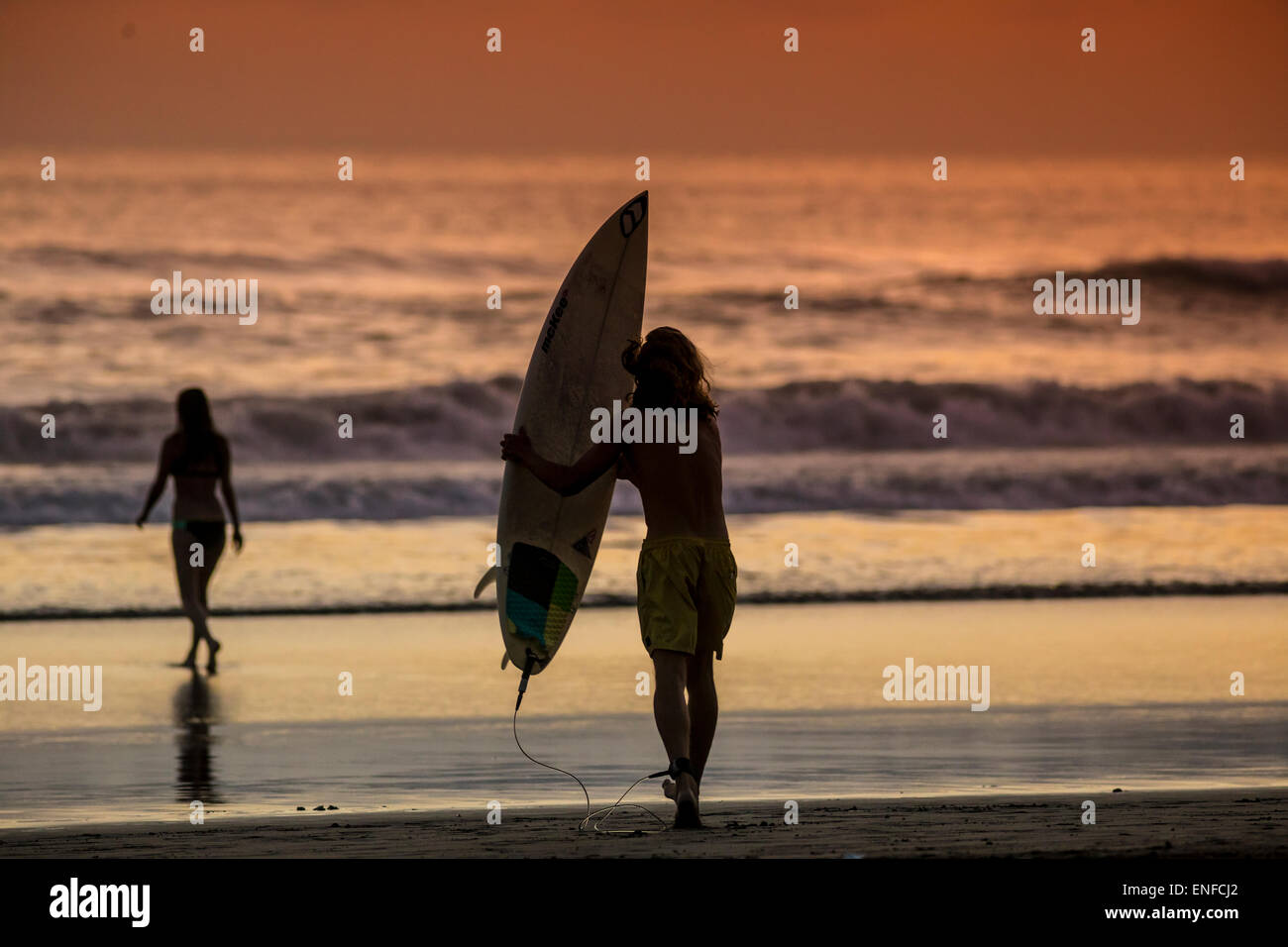 Surfer at sunset Stock Photo - Alamy