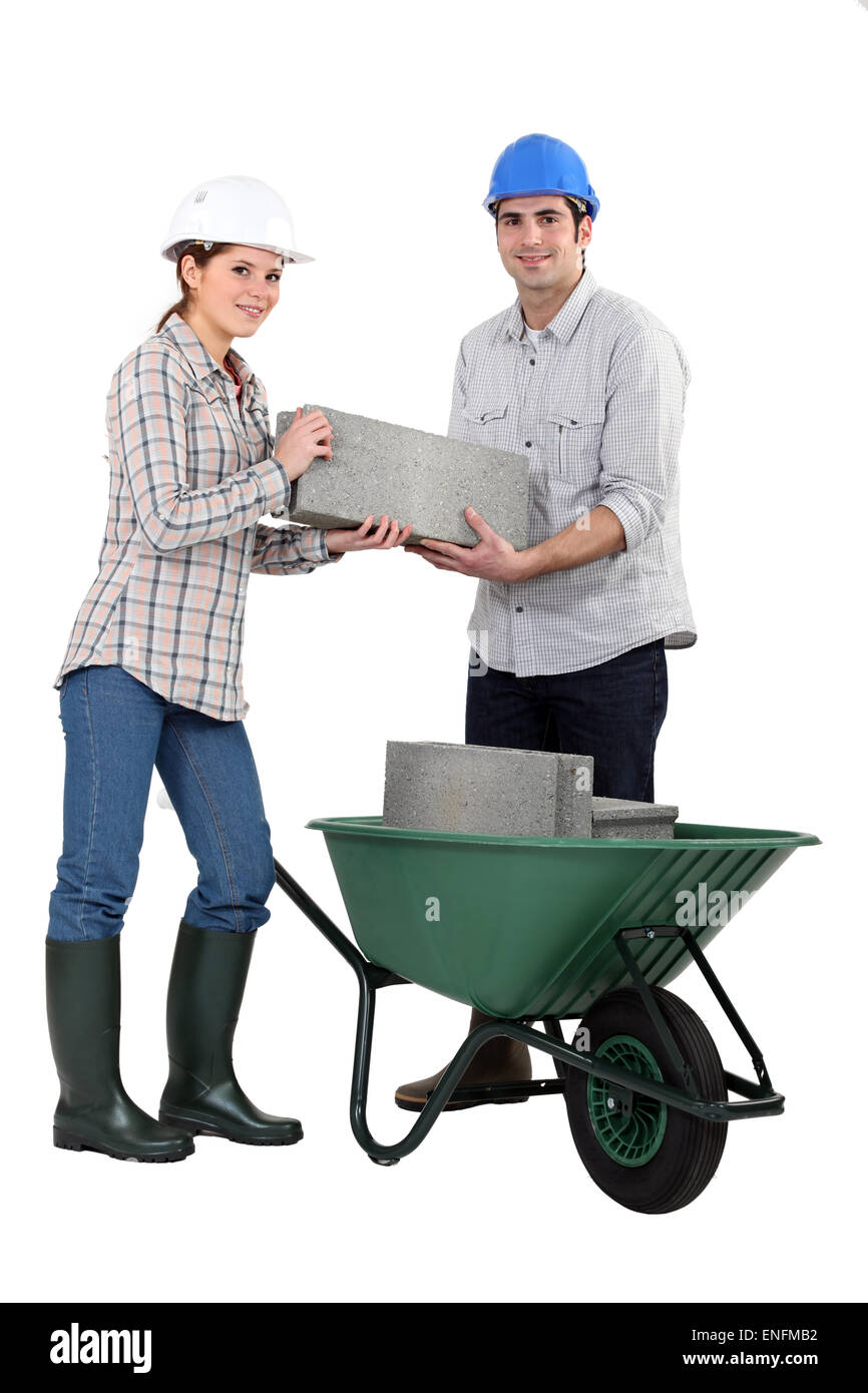 Couple carrying bricks in wheelbarrow Stock Photo - Alamy