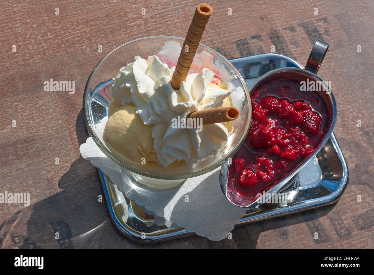 Ice cream sundae with whipped cream and hot raspberries Stock Photo - Alamy