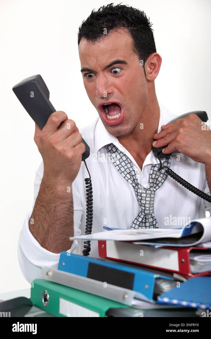 Stressed businessman screaming at a phone Stock Photo - Alamy