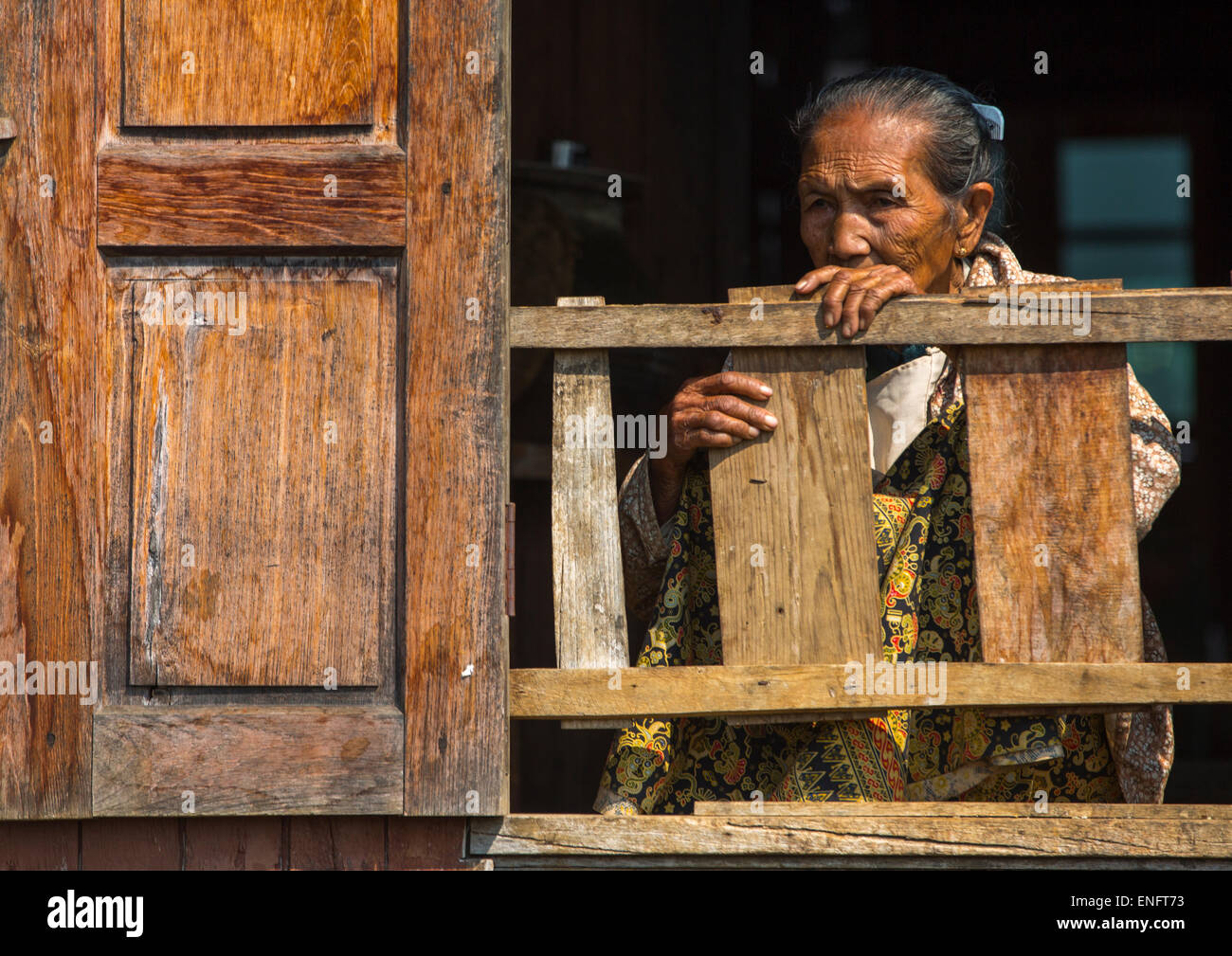 Burmese Woman Looking Out Of Stilt House Window, Inle Lake, Myanmar ...