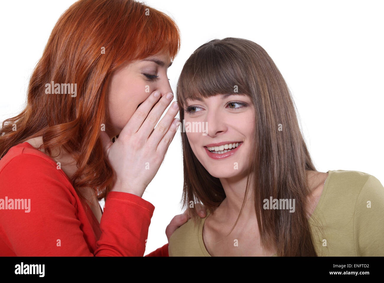 Young woman whispering a secret into her friend's ear Stock Photo - Alamy