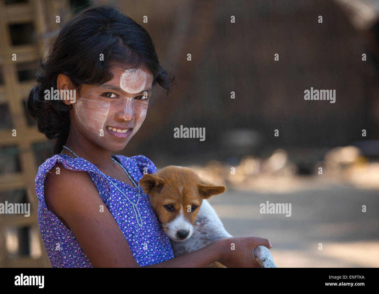Girl With Thanaka On Cheeks Carrying A Dog, Ngapali, Myanmar Stock ...