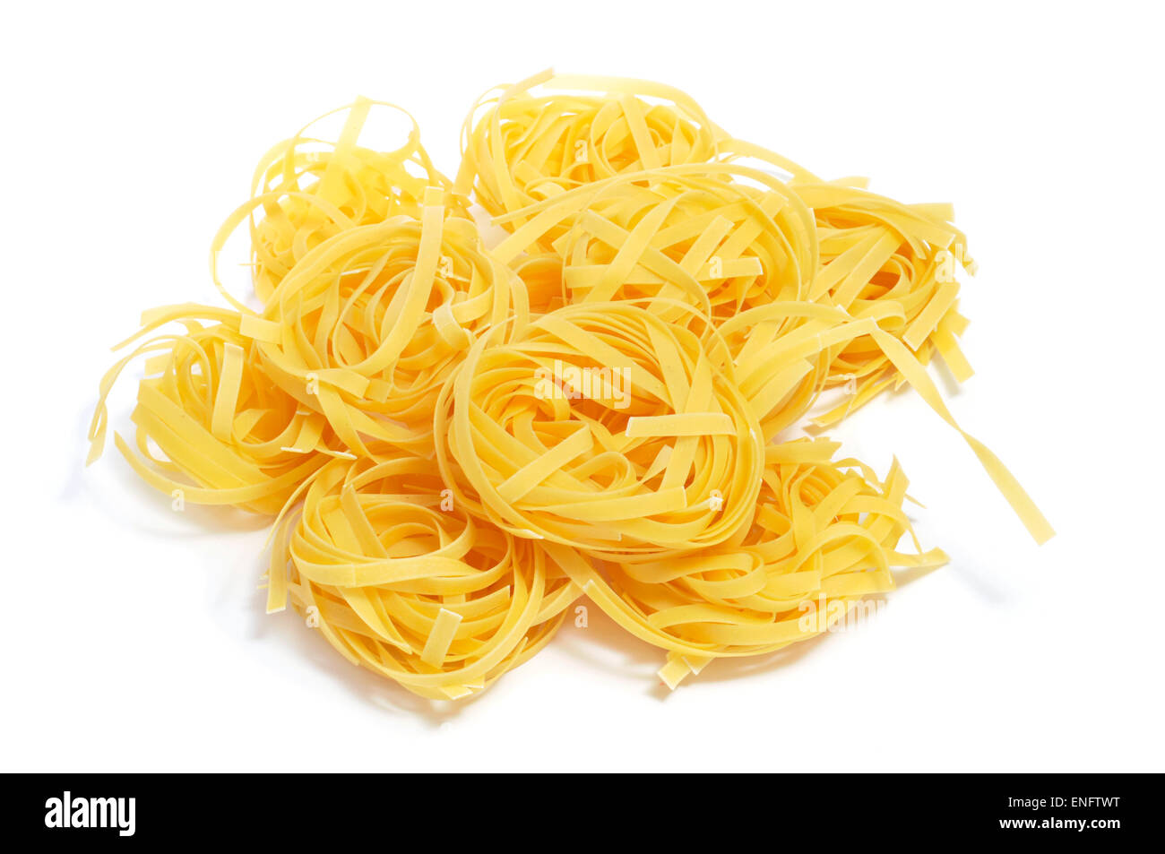 a pile of uncooked tagliatelle on a white background Stock Photo - Alamy
