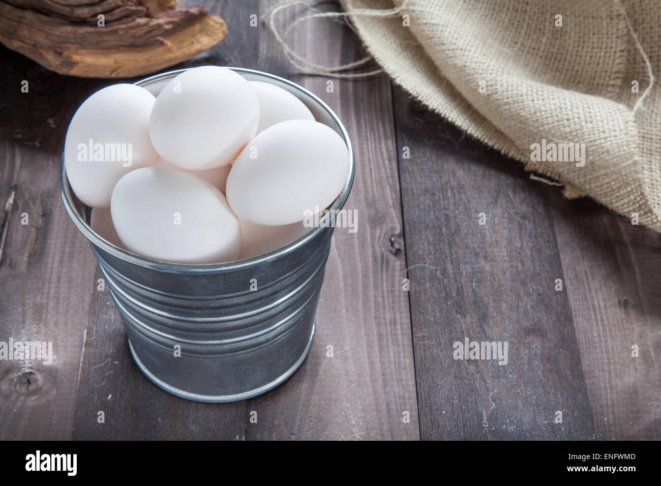 Eggs in a bucket on a black wooden table Stock Photo - Alamy