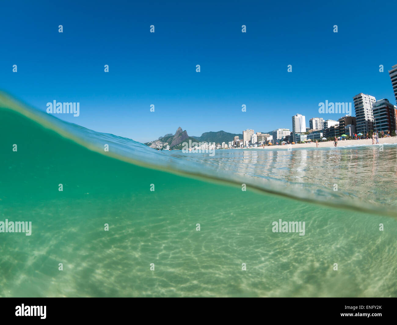 Over-under underwater view of clear green tropical waters off the shore ...