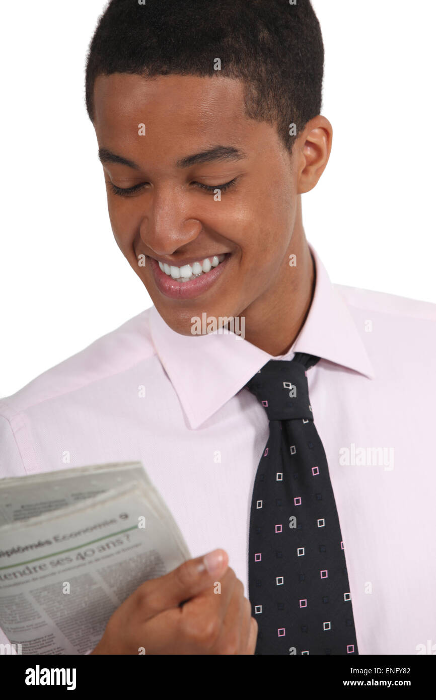 Young man reading a newspaper Stock Photo - Alamy