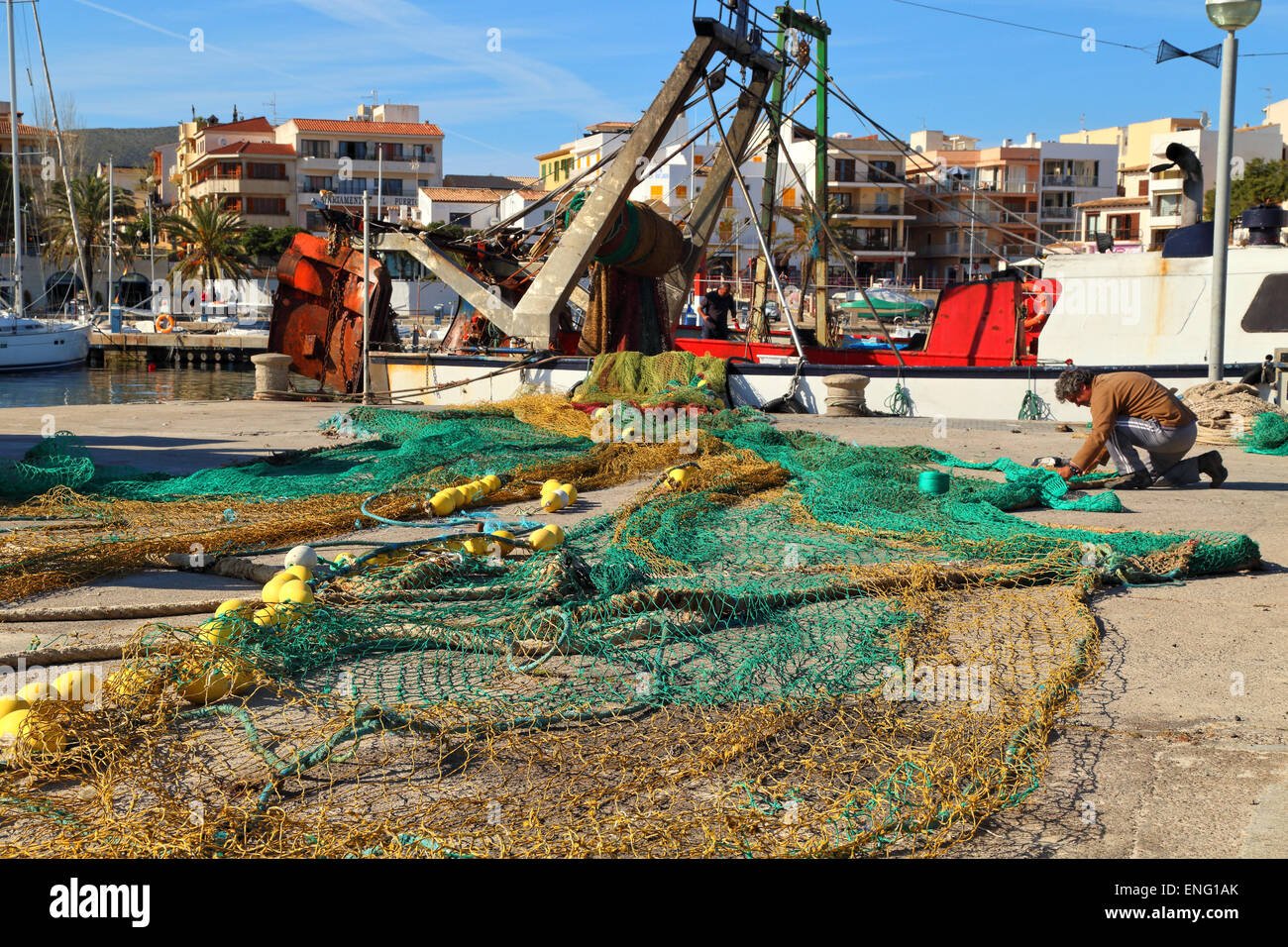 Fishermen repairing their fishing net, port of Cala Rajada Stock Photo ...