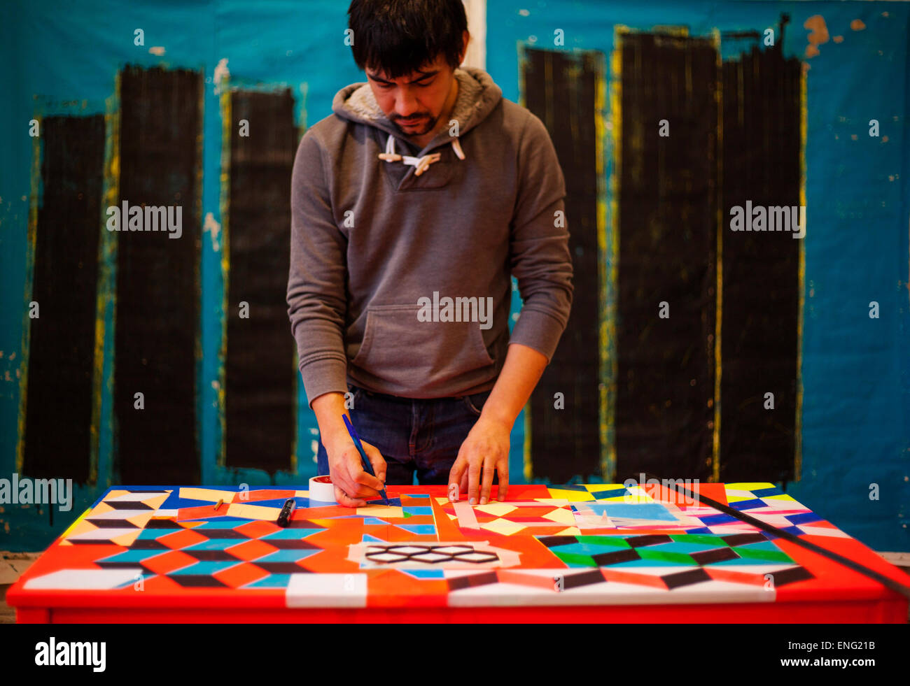 Mari man drawing on colorful table Stock Photo - Alamy