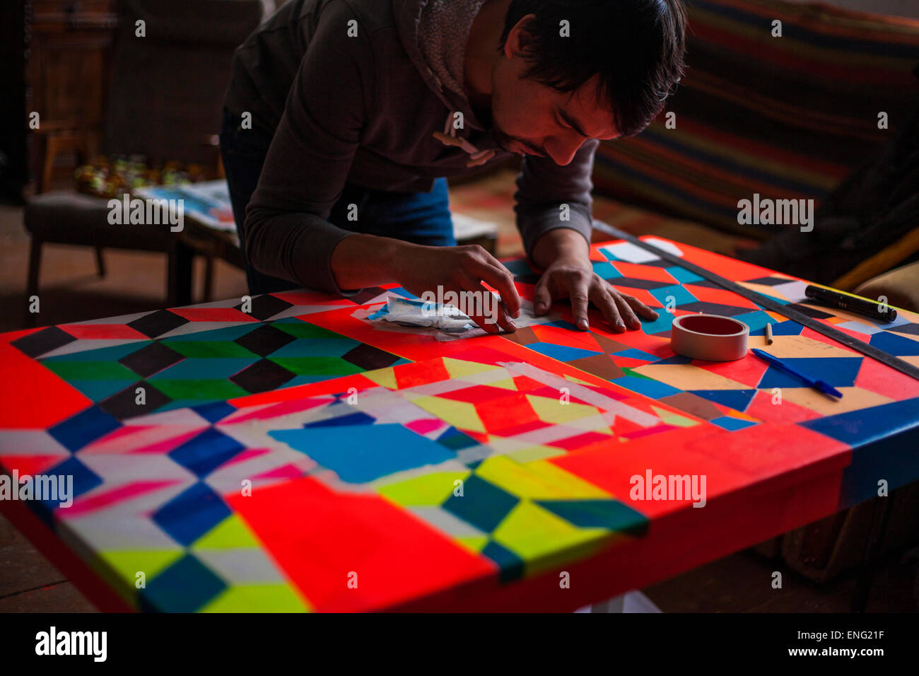 Mari man designing colorful table Stock Photo - Alamy