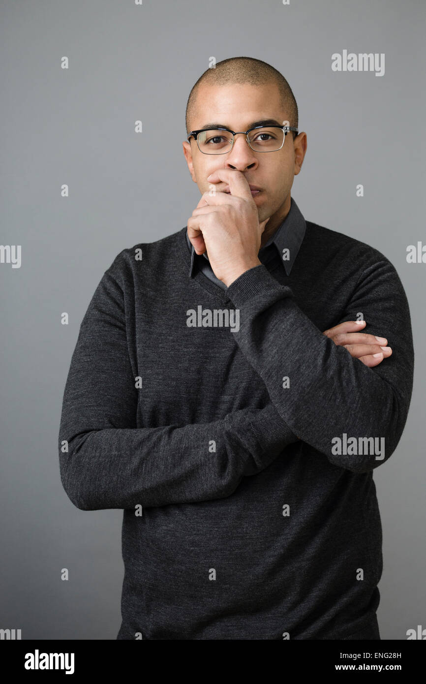 Mixed race man holding chin in hand Stock Photo - Alamy