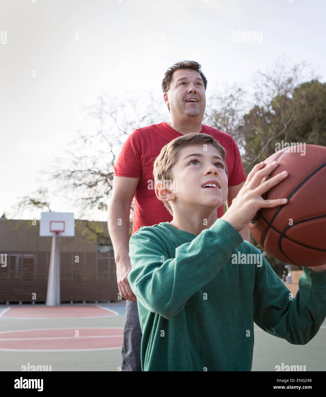 Caucasian father watching son hold basketball on court Stock Photo - Alamy