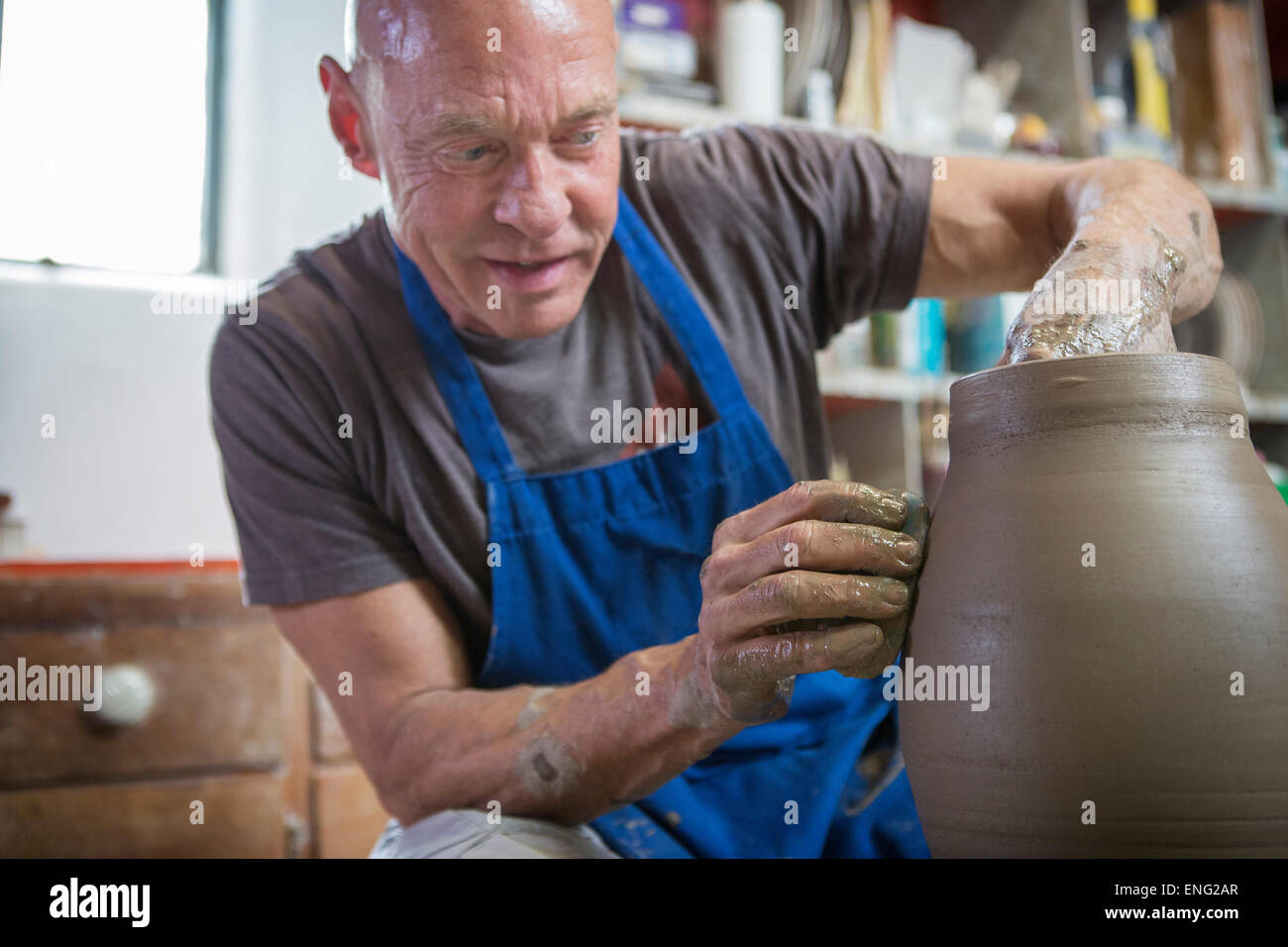 Older Caucasian man forming pottery on wheel in ceramics studio Stock ...