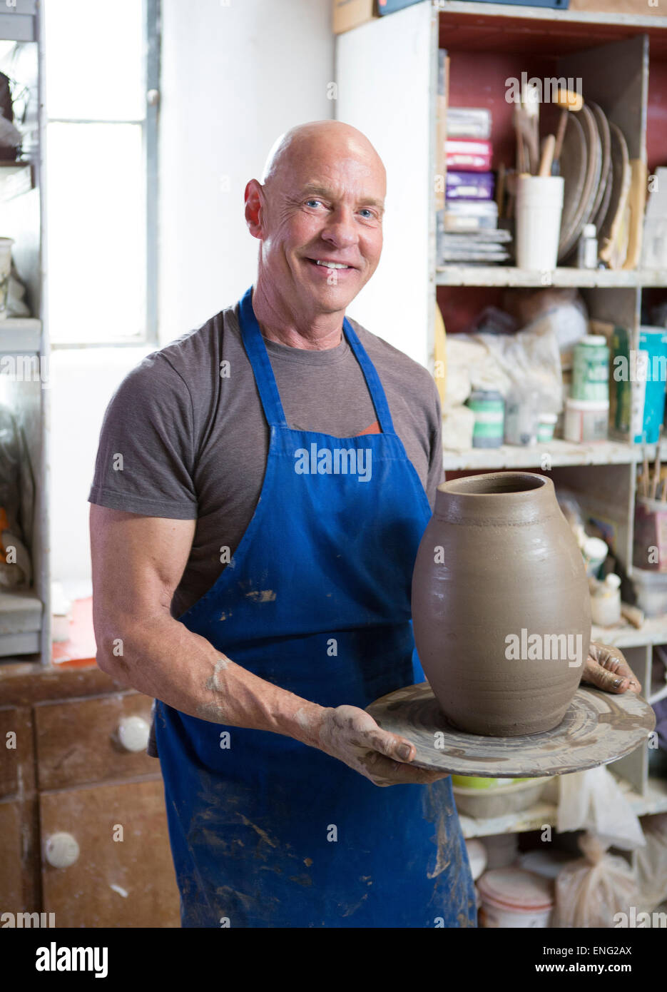 Proud older Caucasian man holding pottery in ceramics studio Stock ...