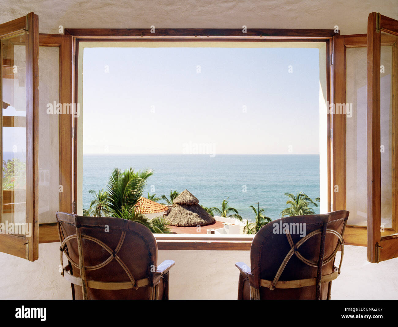 Empty chairs facing open window overlooking ocean Stock Photo - Alamy