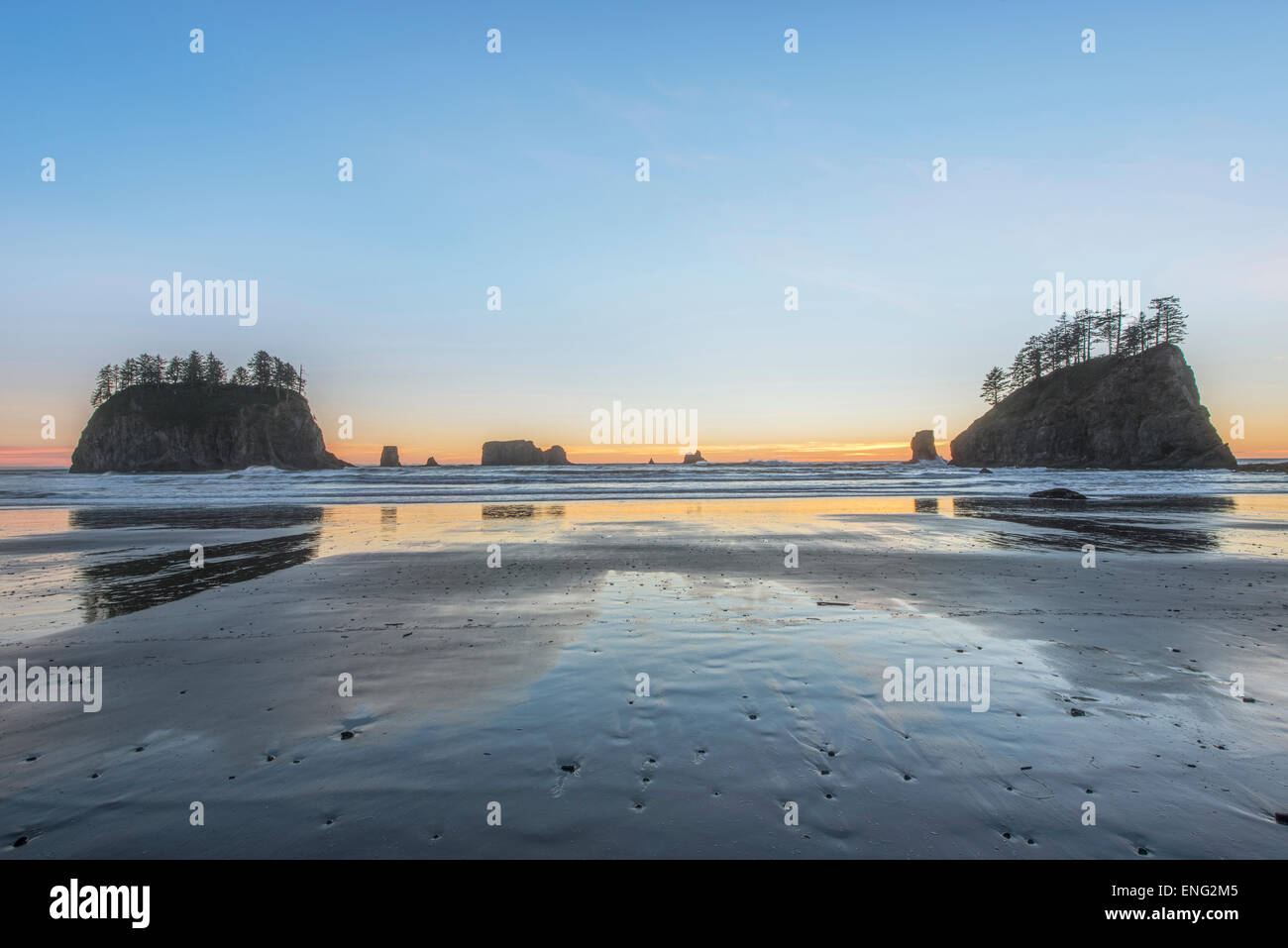 Sunrise horizon behind rock formations on beach Stock Photo - Alamy