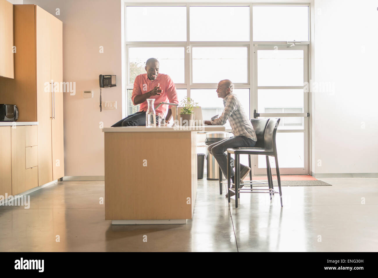 Business people talking in office kitchen Stock Photo - Alamy