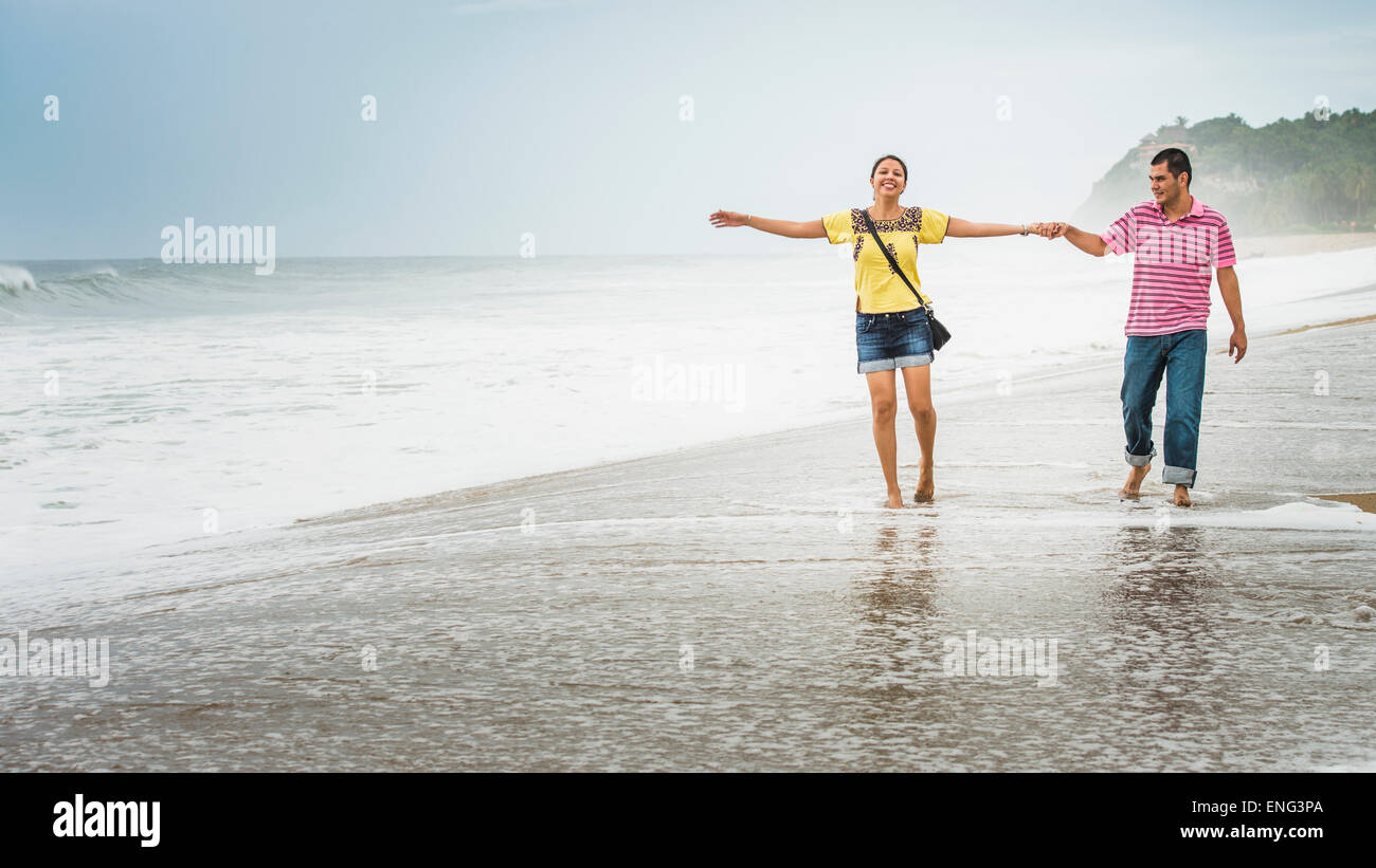 Hispanic couple playing in waves on beach Stock Photo - Alamy