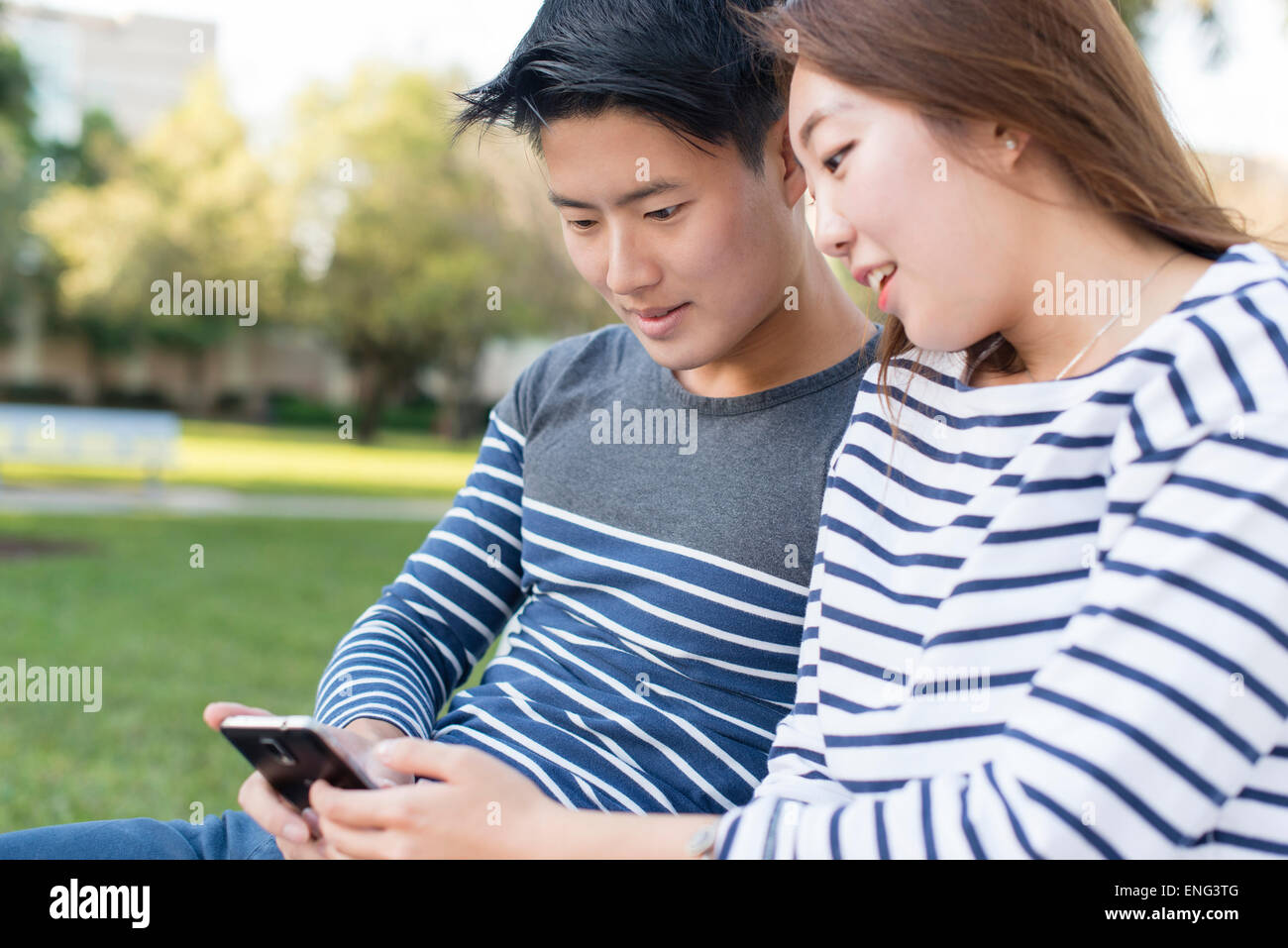 Young couple in park using hi-res stock photography and images - Alamy