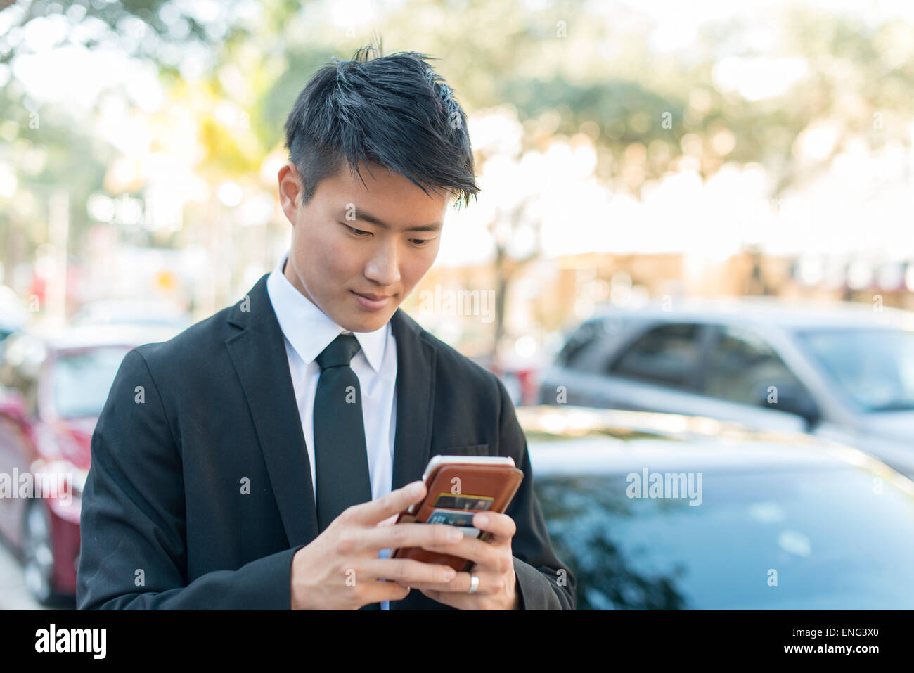 Korean businessman using cell phone outdoors Stock Photo - Alamy