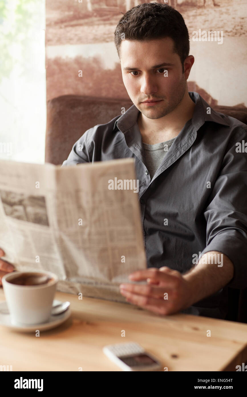 Man reading newspaper and drinking coffee in cafe Stock Photo - Alamy