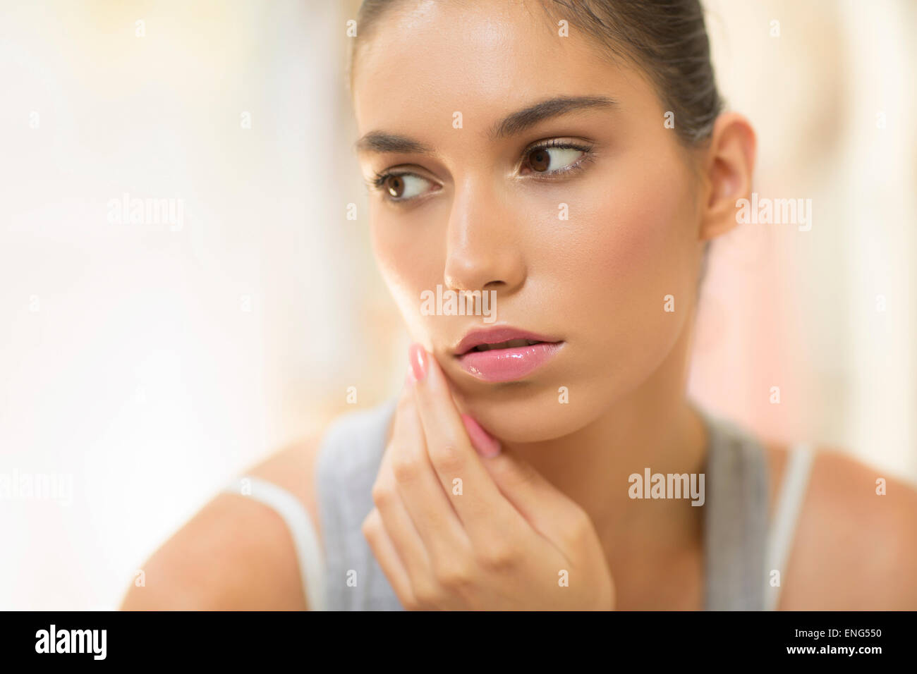 Close up of pensive woman touching cheek Stock Photo - Alamy