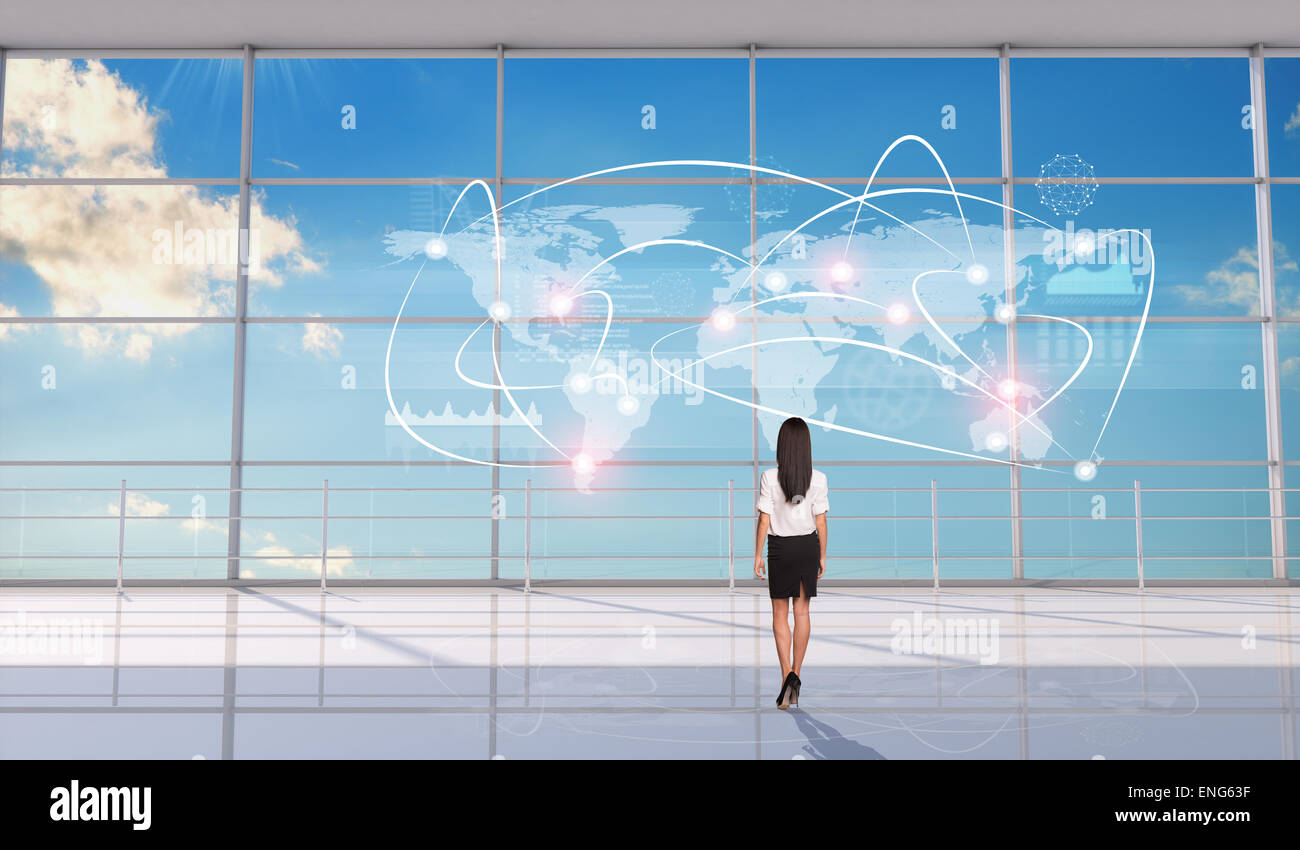 Businesswoman standing back and looking at map Stock Photo - Alamy