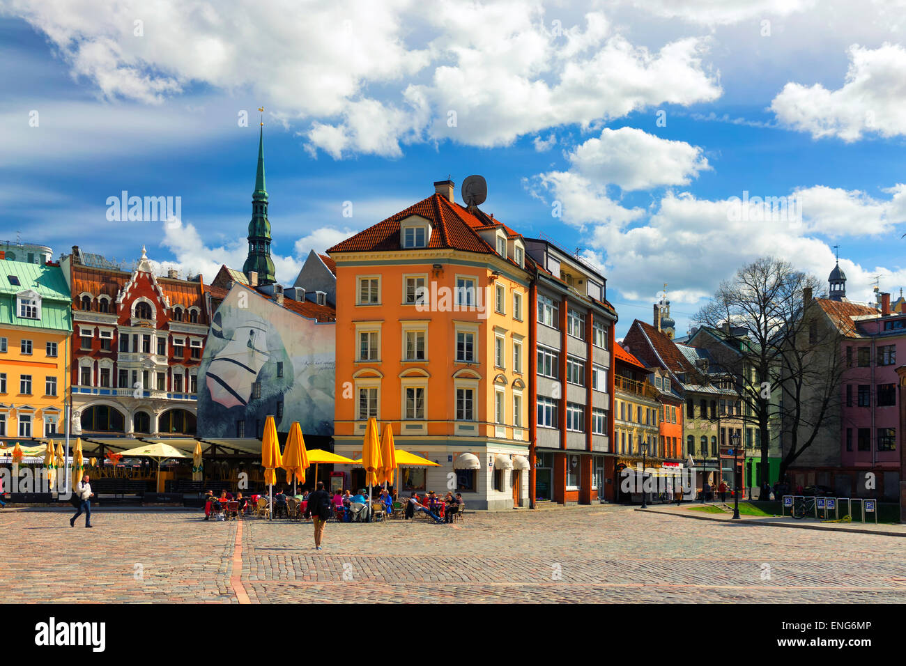 Summer cafe with umbrellas in Dome Square in Riga on a sunny spring day ...