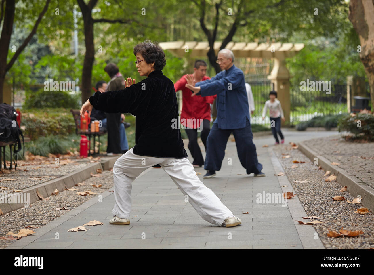 A group of people practising taiji quan (or taichi) in a city centre ...