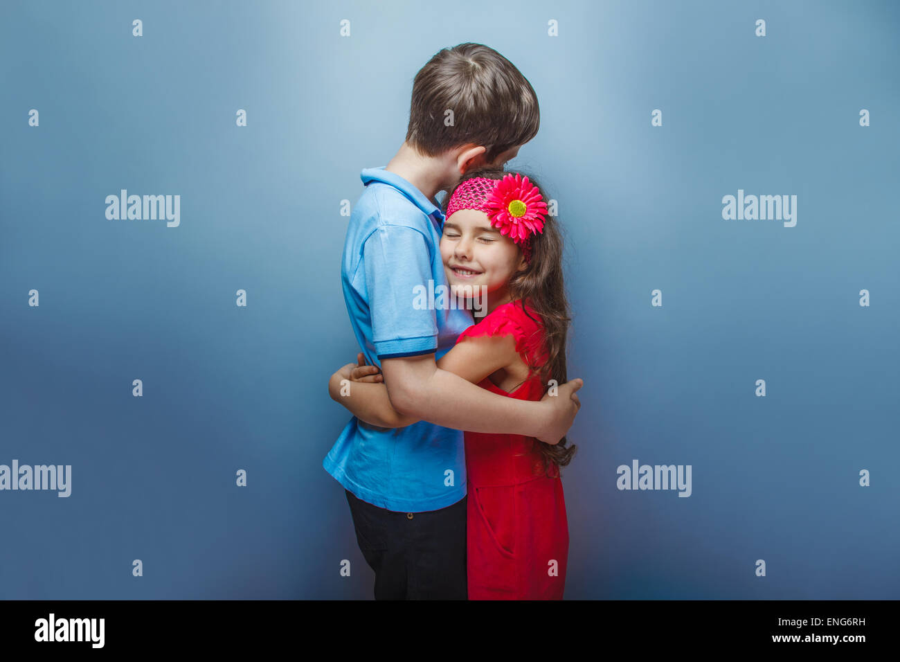 teen girl hugging a teenage boy on a gray background Stock Photo - Alamy