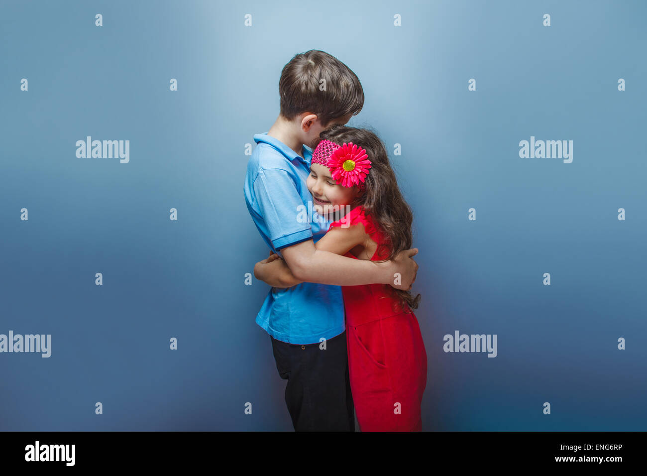 teen girl hugging a teenage boy on a gray background Stock Photo - Alamy