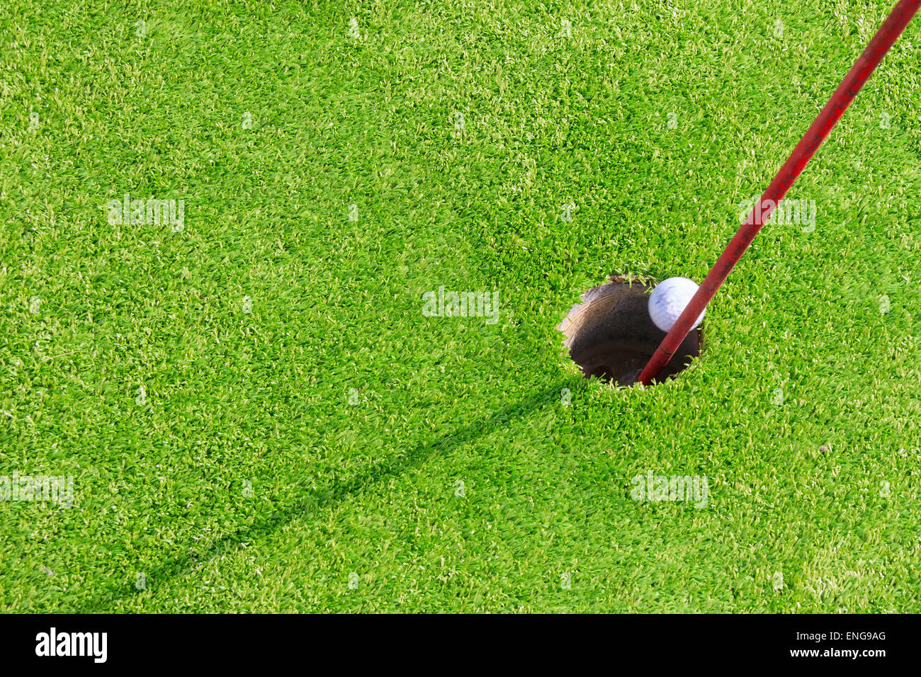 Close-up of mini golf ball going in the hole Stock Photo - Alamy