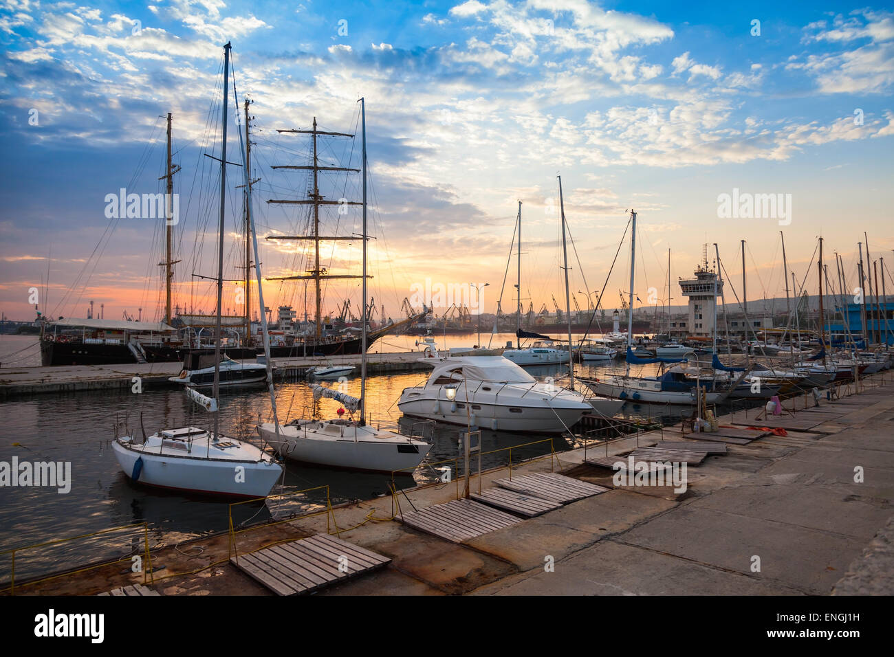 Sailing ships and yachts stand moored in Varna port at the sunset ...