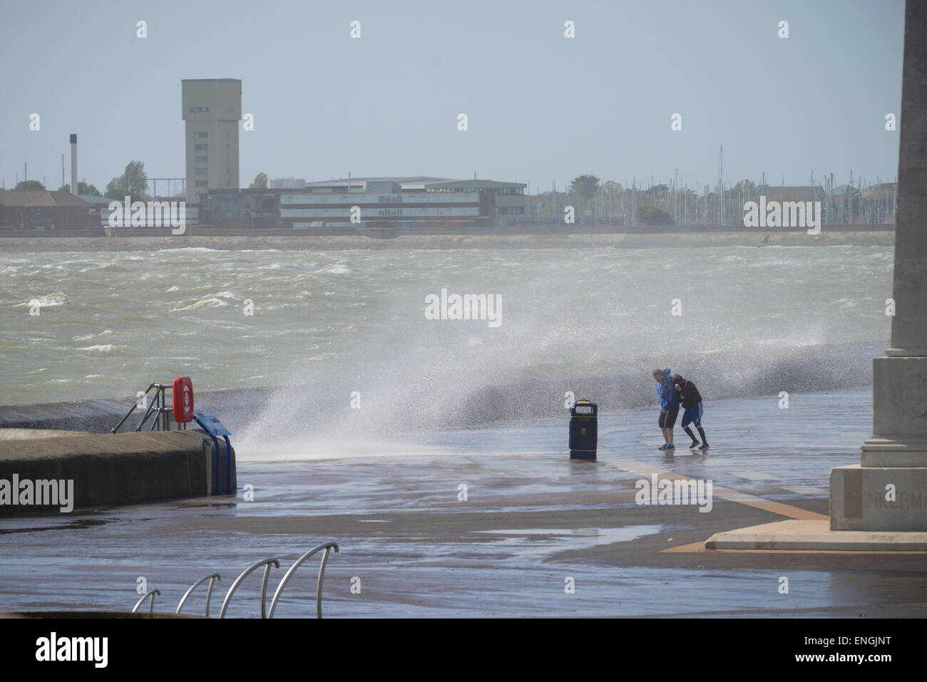 During bad weather a man and a woman struggle to walk along the ...